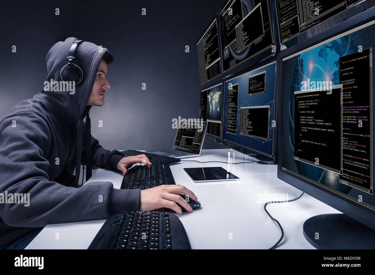 Rear View Of A Hacker Using Multiple Computers For Stealing Data In Office Stock Photo - Alamy
