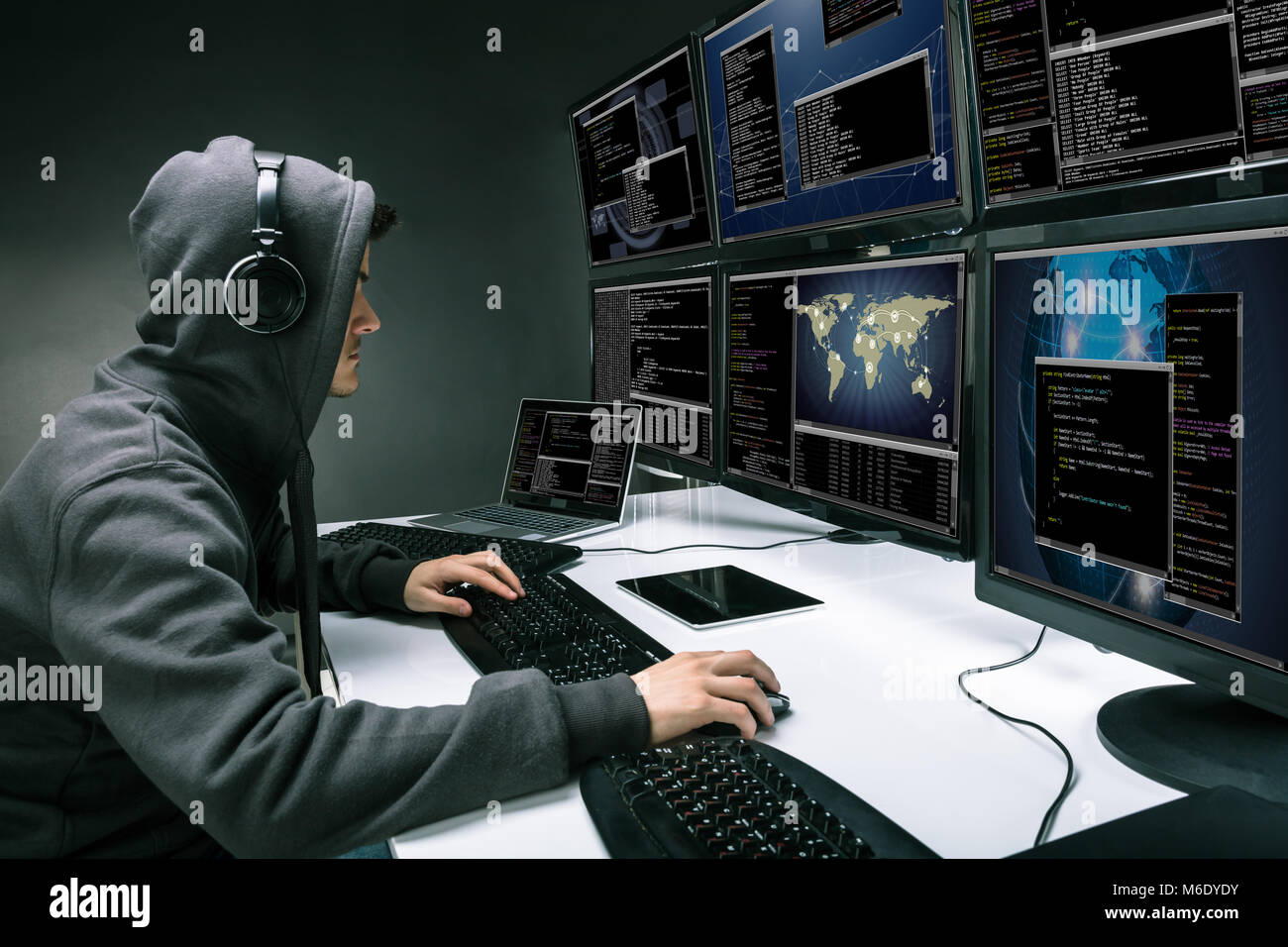 Rear View Of A Hacker Using Multiple Computers For Stealing Data In 8557