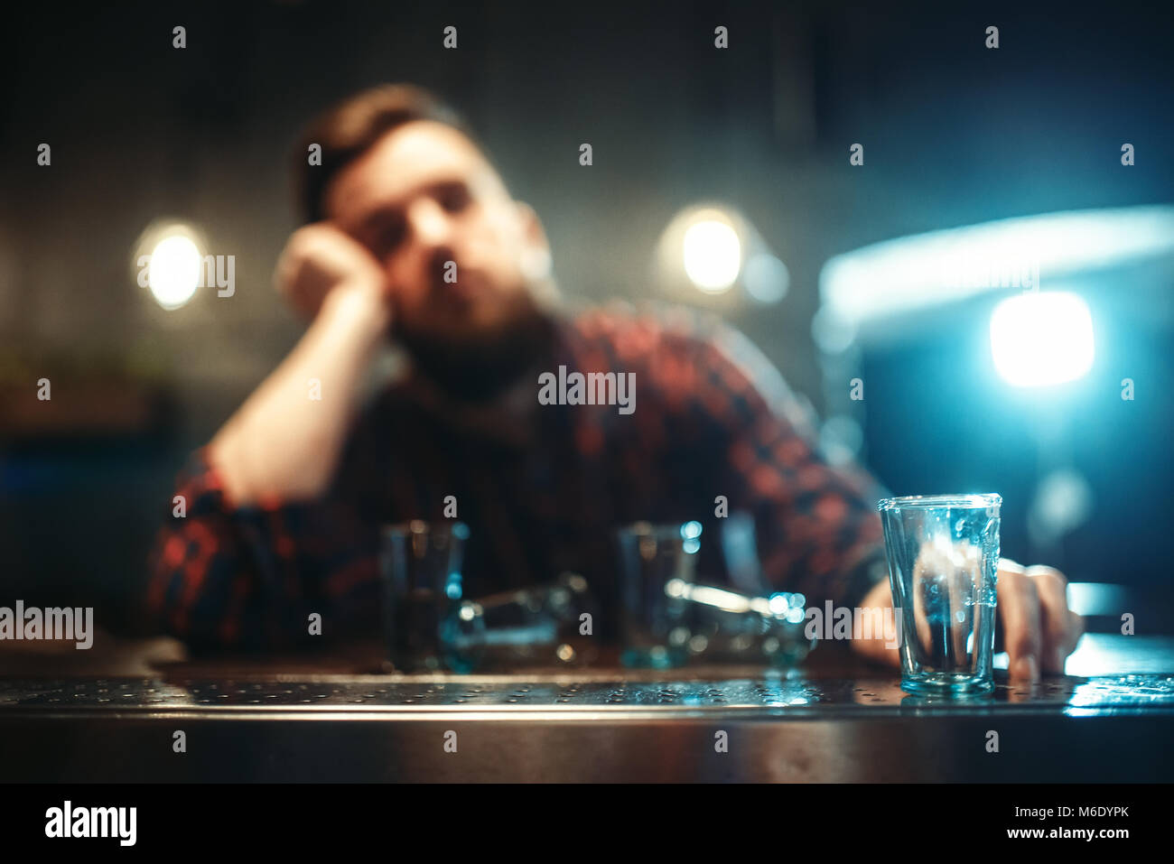 Drunk man sleeps at the bar counter, alcohol addiction. Male person in ...