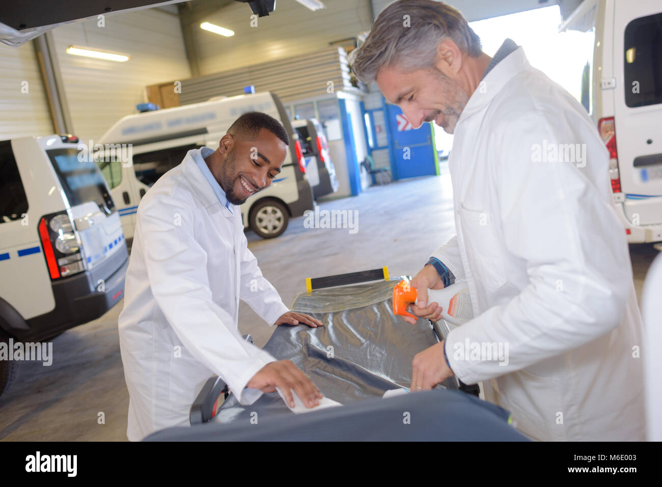 Paramedics cleaning stretcher Stock Photo - Alamy