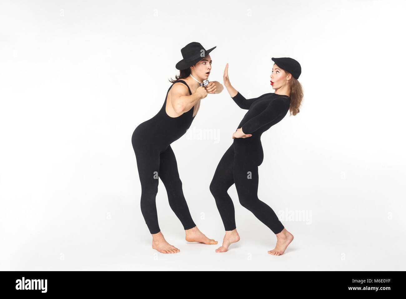 Hey you! Woman showing stop sign young man. Studio shot, isolated on ...