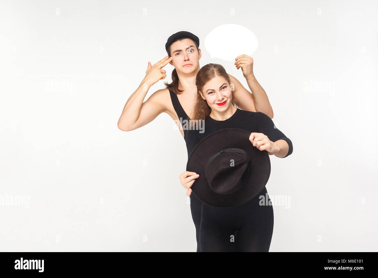 Traffic rules. Couple driving a car, man showing gun sign. Studio shot ...