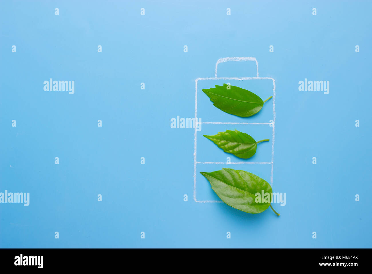 Eco green energy battery on blue background Stock Photo - Alamy