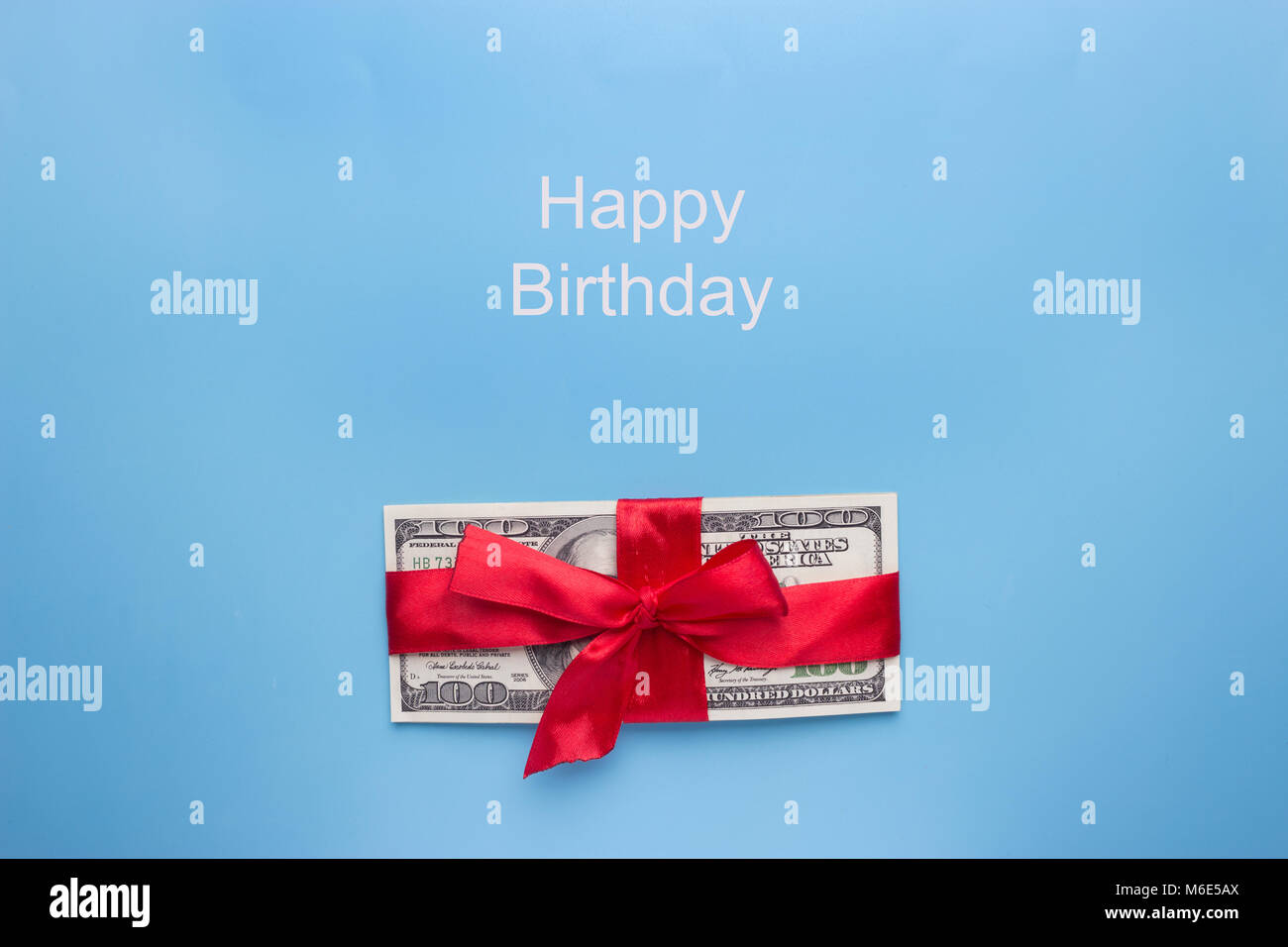 Red Ribbon on Bunch of US dollars on blue background Stock Photo - Alamy