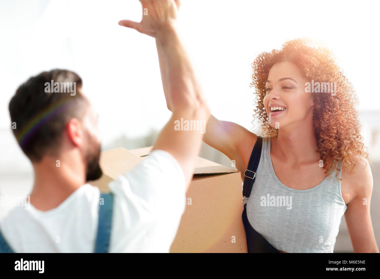 Happy and young couple giving a high five Stock Photo - Alamy