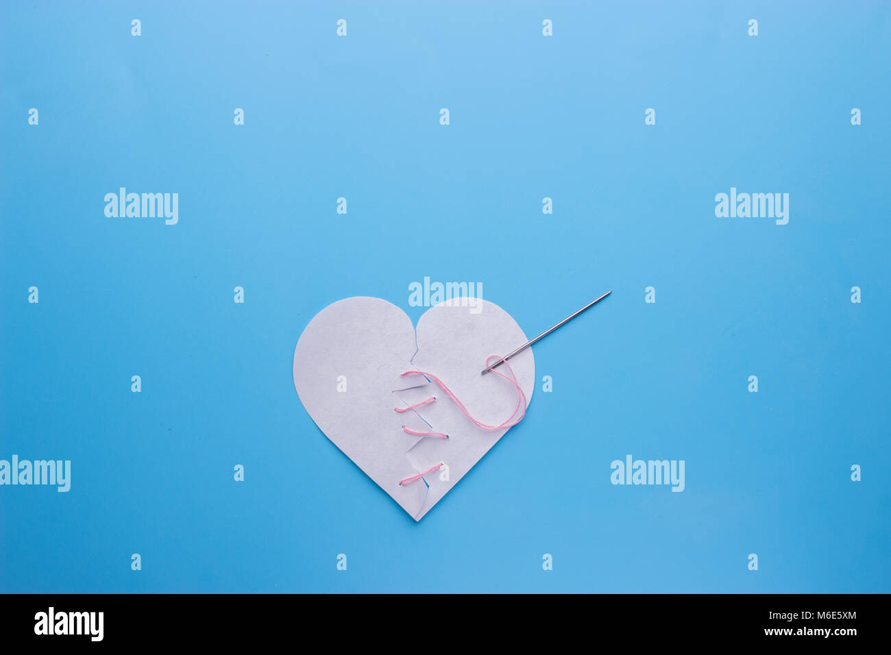 Healing broken heart. needle with pink thread Stock Photo - Alamy
