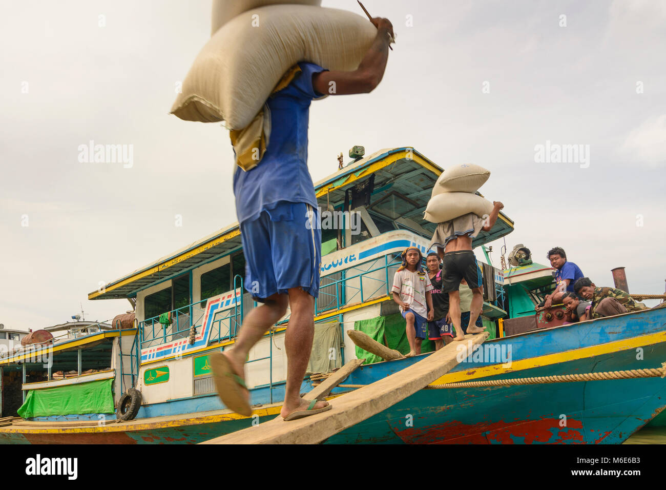 Mandalay: men load transport rice bag to cargo ship at Irrawaddy ...