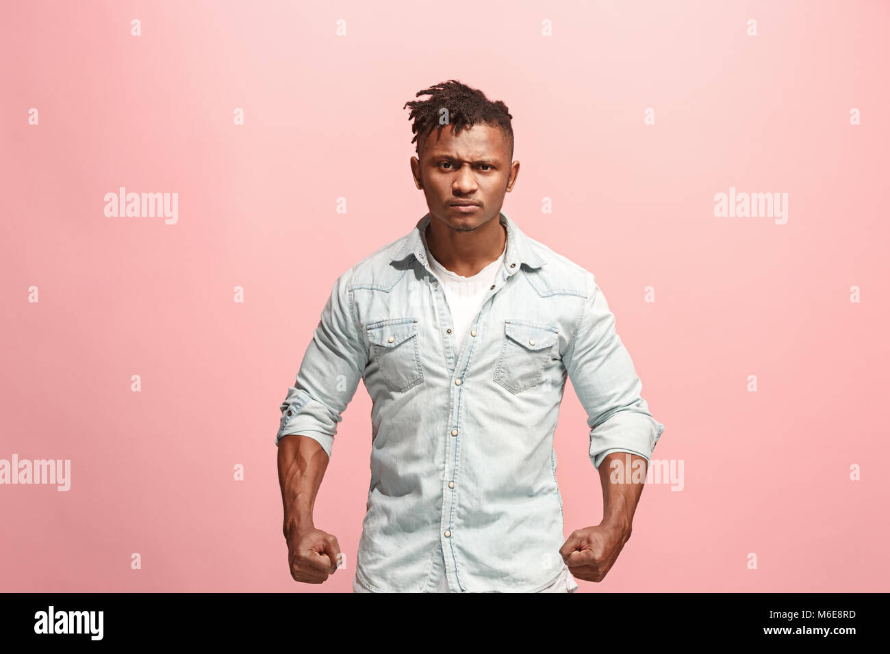 The young emotional angry afro man screaming on pink studio background ...