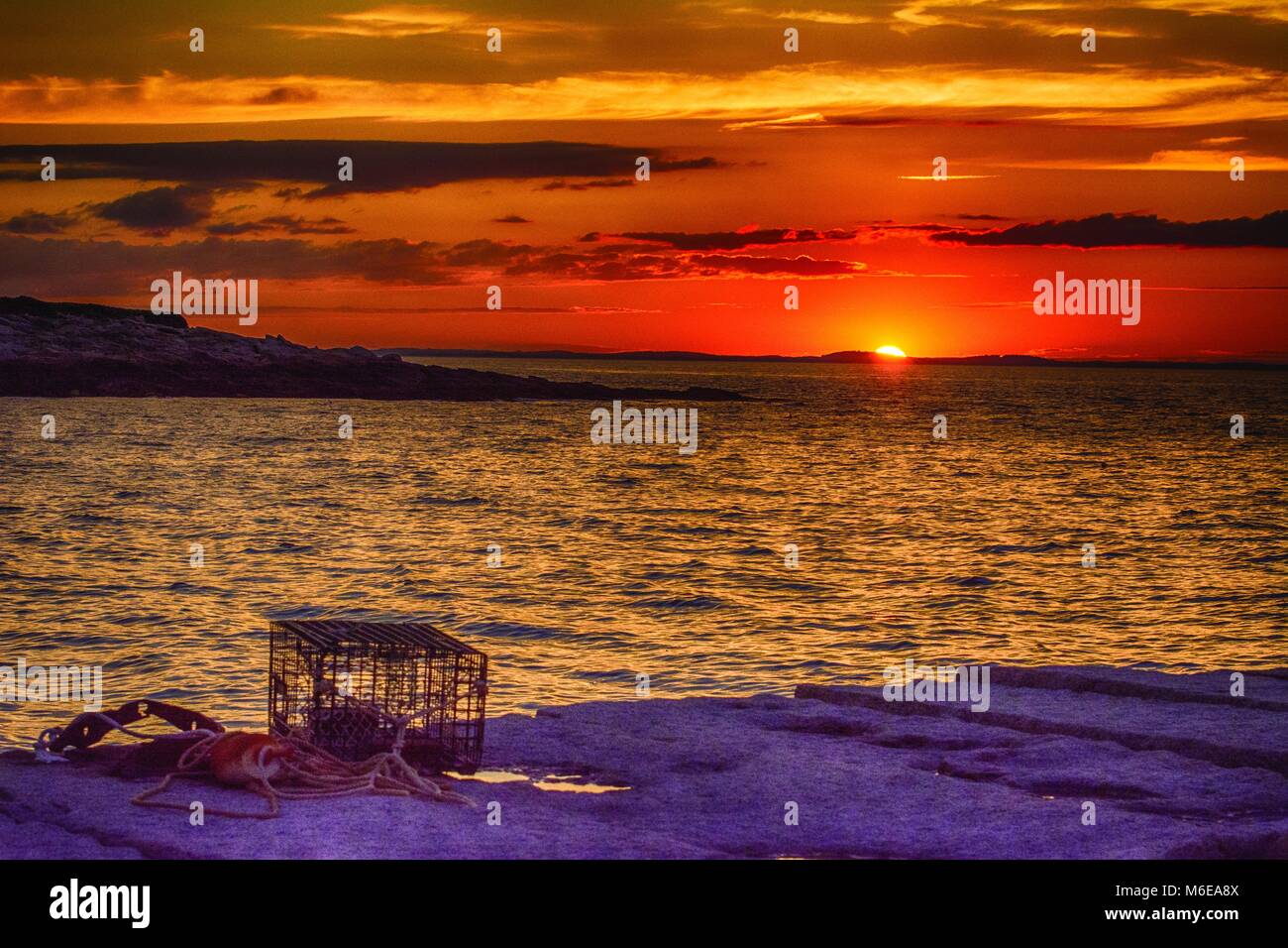 Sun setting in the summer months by the cove Stock Photo - Alamy