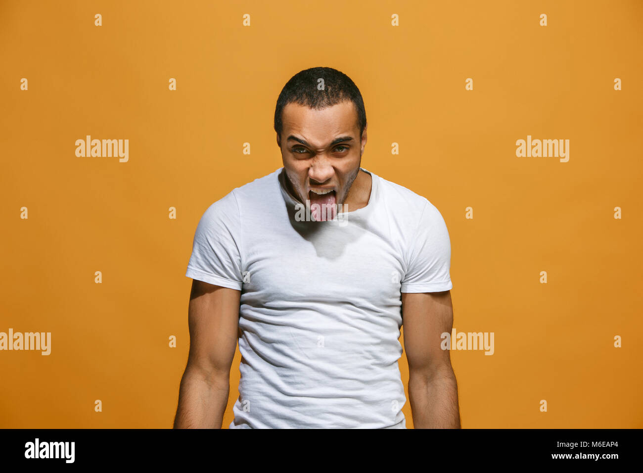The young emotional angry and scared man standing and looking at camera ...