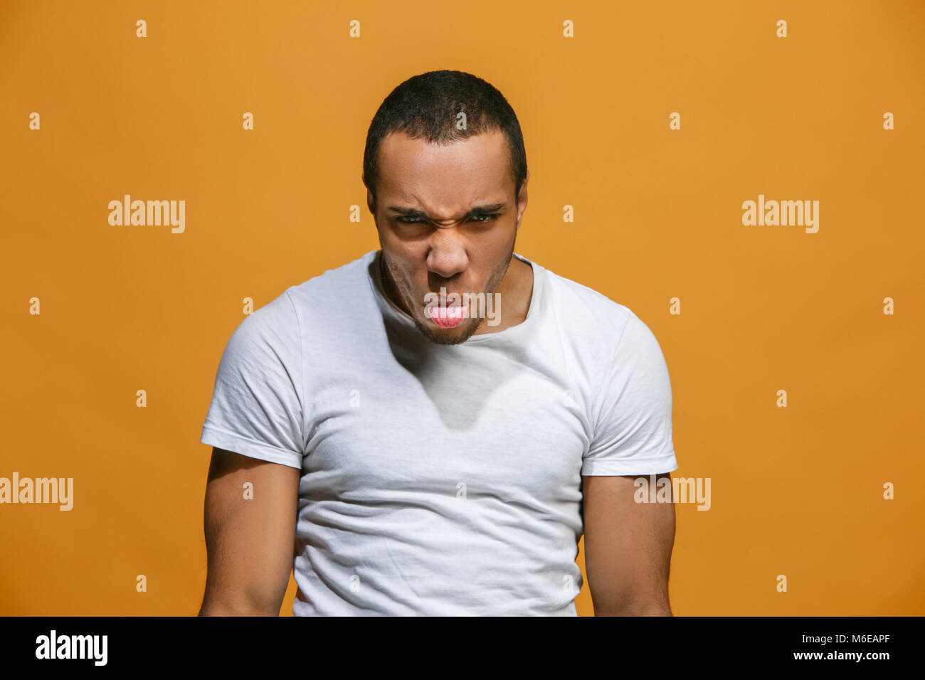 The young emotional angry and scared man standing and looking at camera ...
