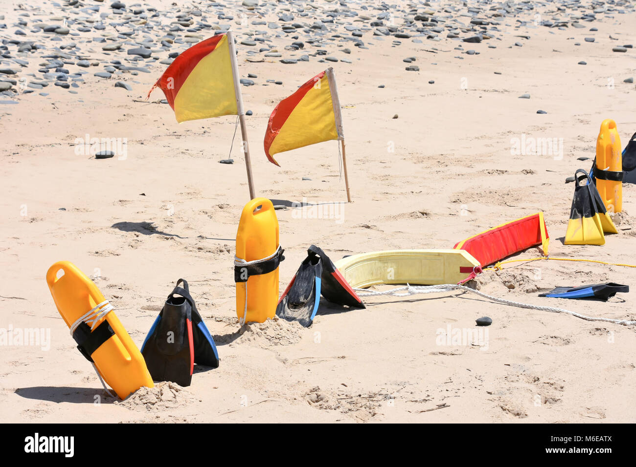 Colorful lifeguard equipment and flags on the beach in yellow and red ...