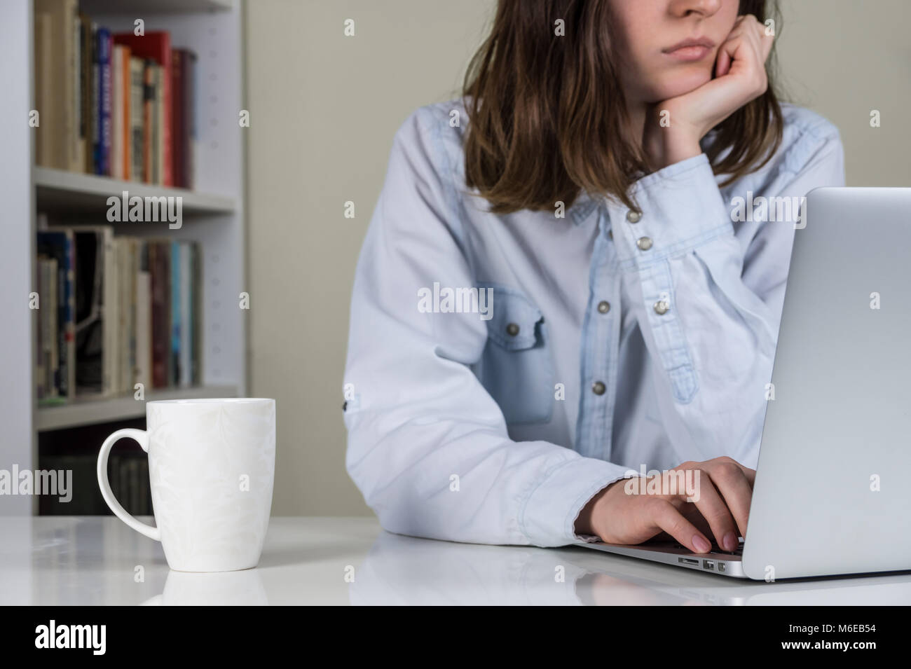 Bored person working at laptop computer Stock Photo - Alamy