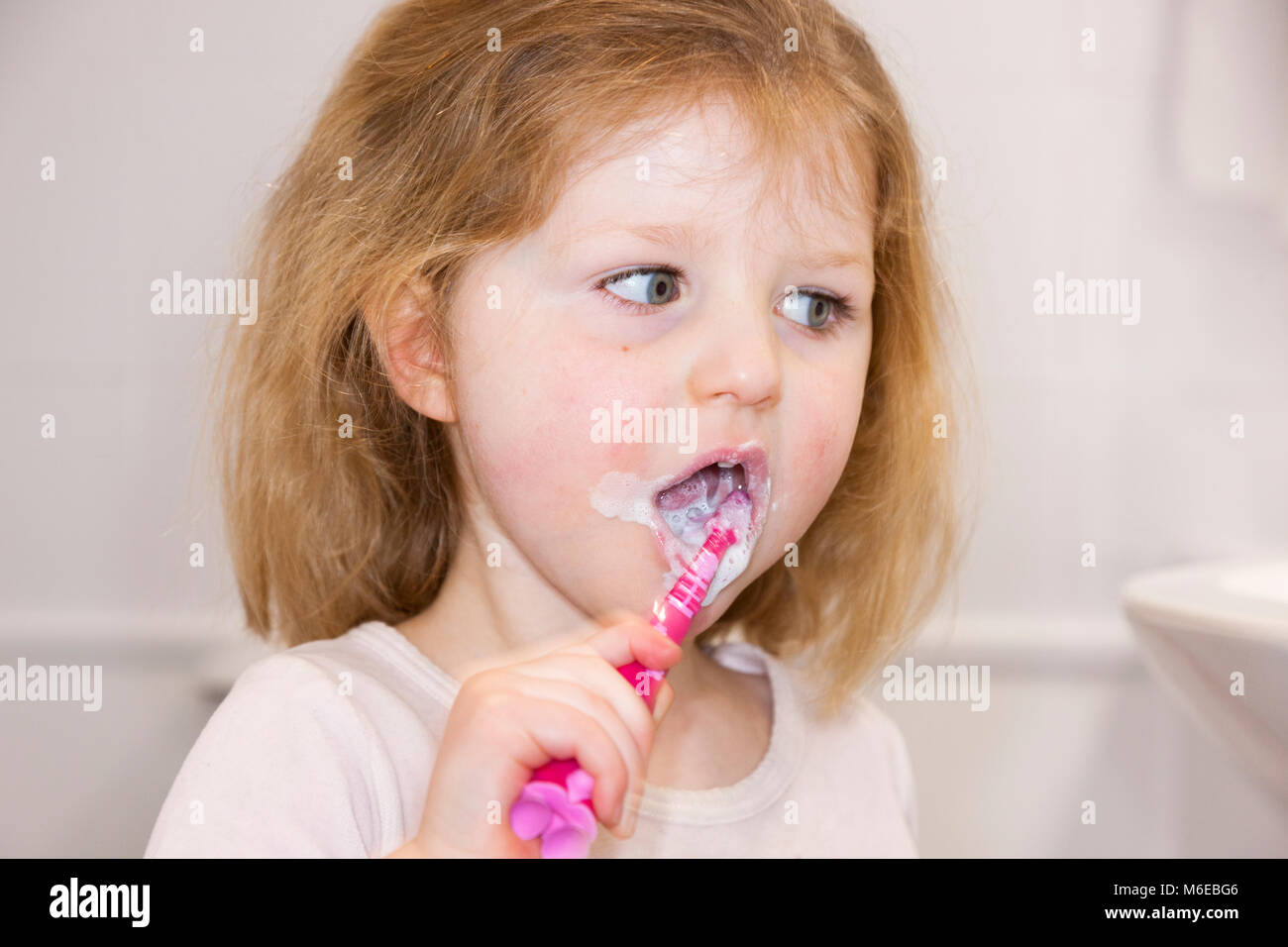 Three year old child / kid aged 3 years brushing her own milk teeth ...