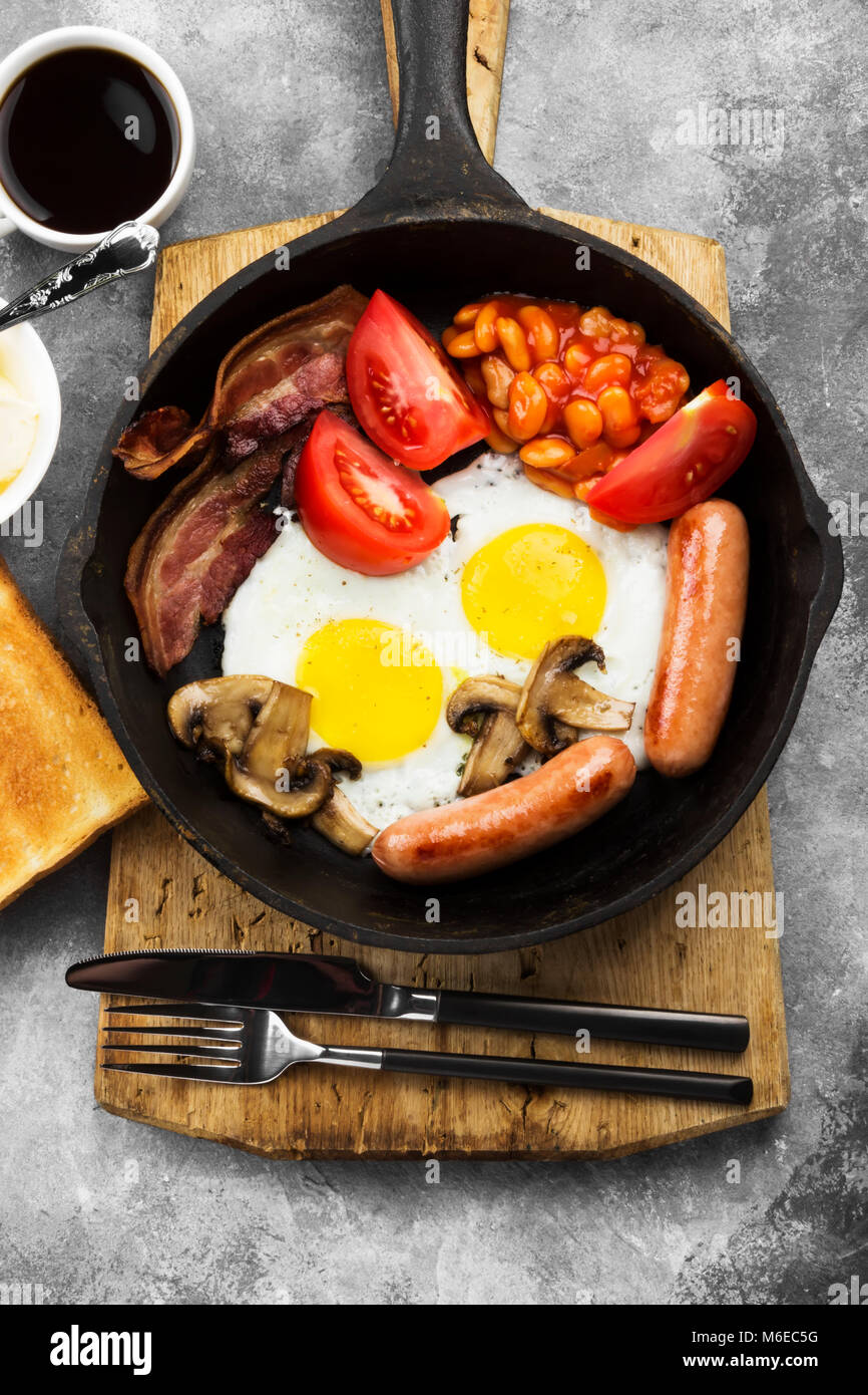 Traditional English breakfast - bacon, sausages, fried eggs, tomatoes ...