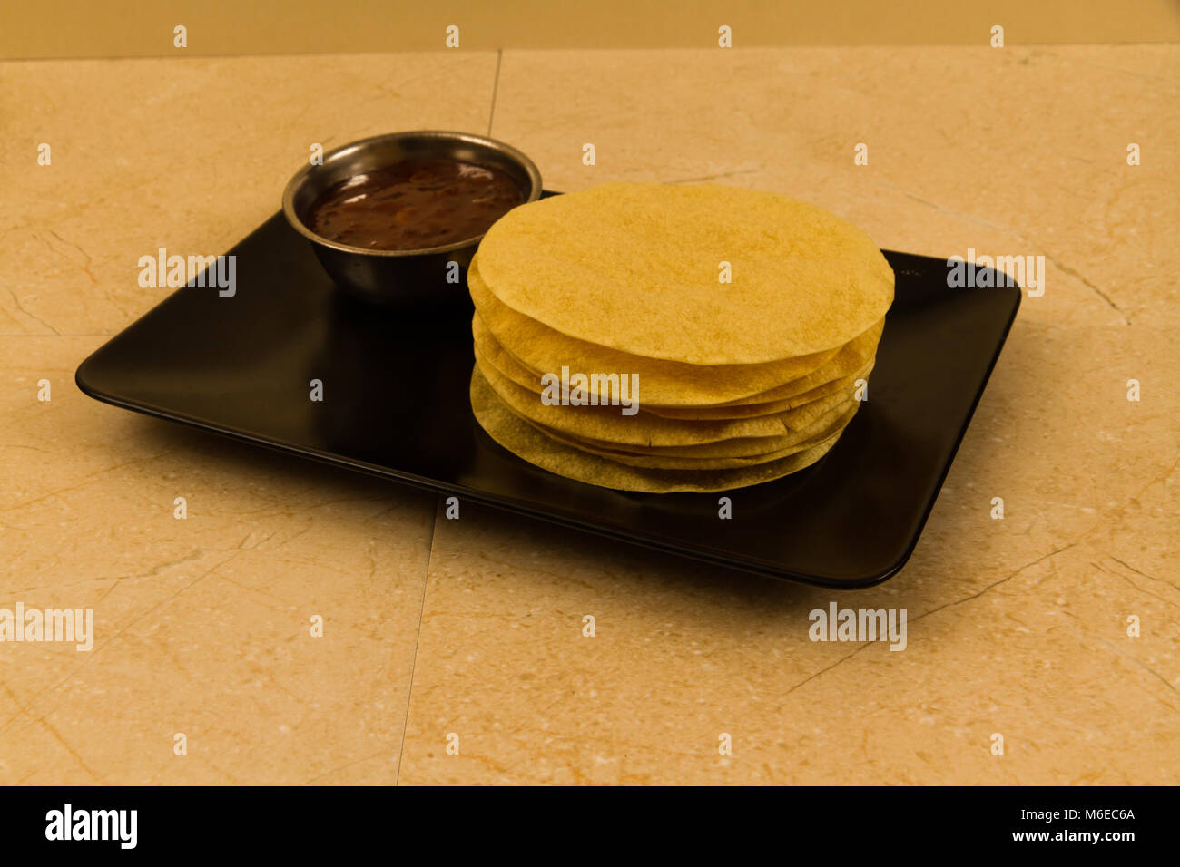 Indian poppadums stacked with bowl of mango chutney Stock Photo - Alamy