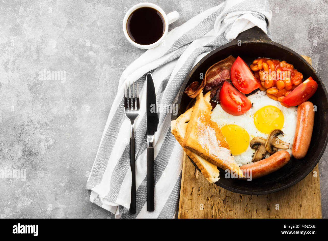 Traditional English breakfast - bacon, sausages, fried eggs, tomatoes ...
