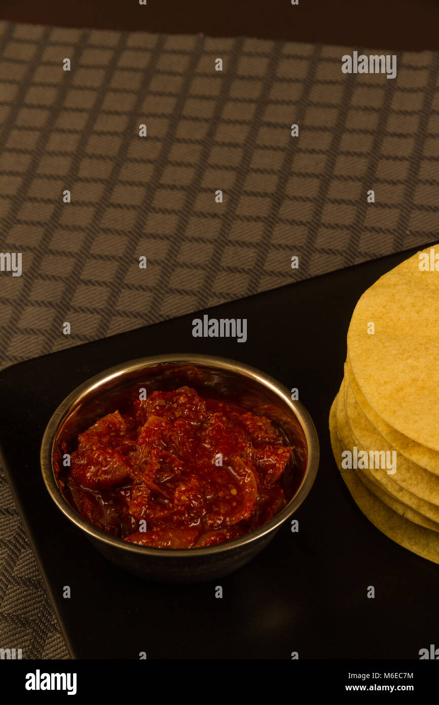 Indian poppadums stacked with bowl of lime pickle and sliced lime Stock ...
