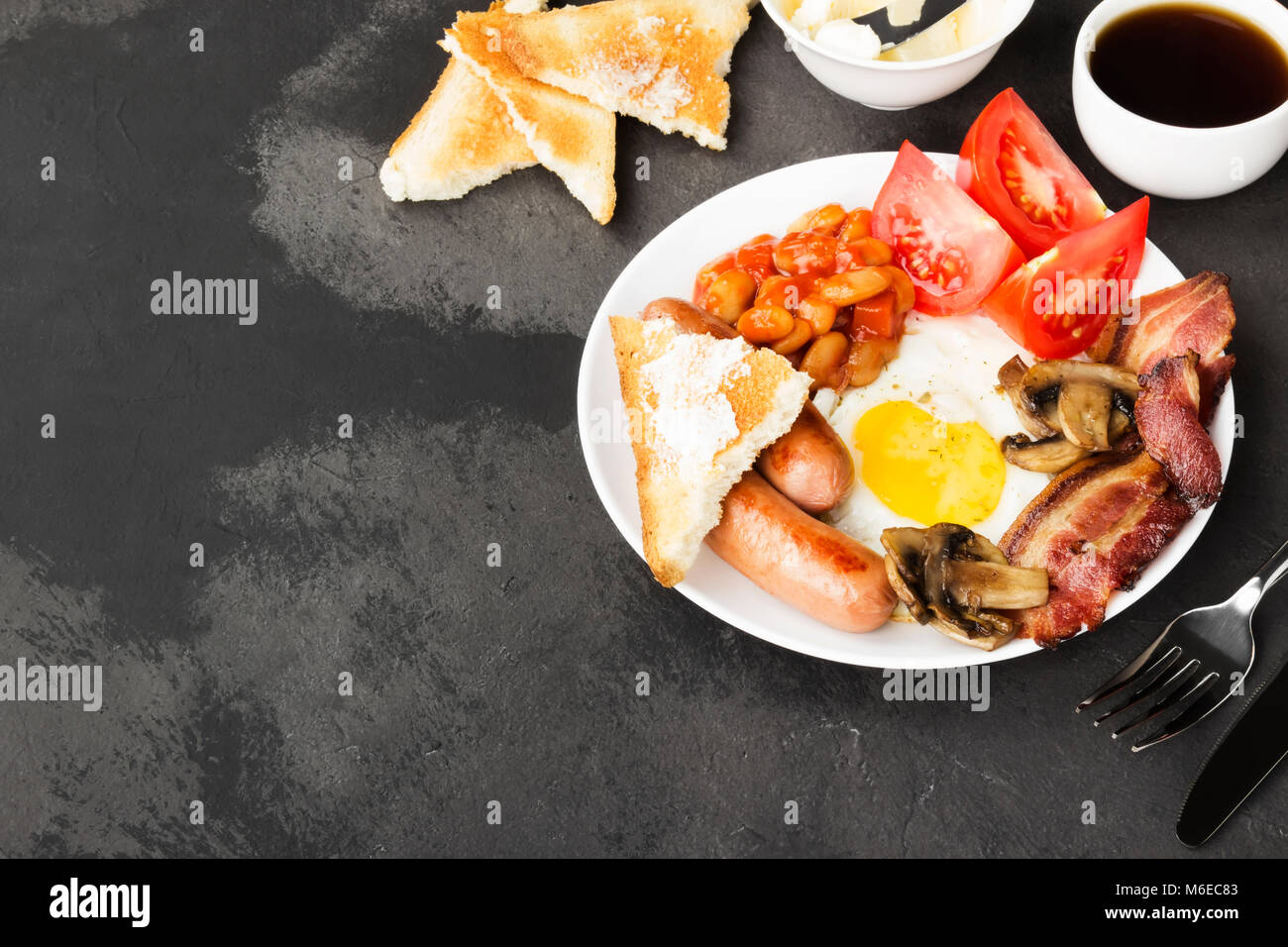 Traditional English breakfast - bacon, sausages, fried eggs, tomatoes ...