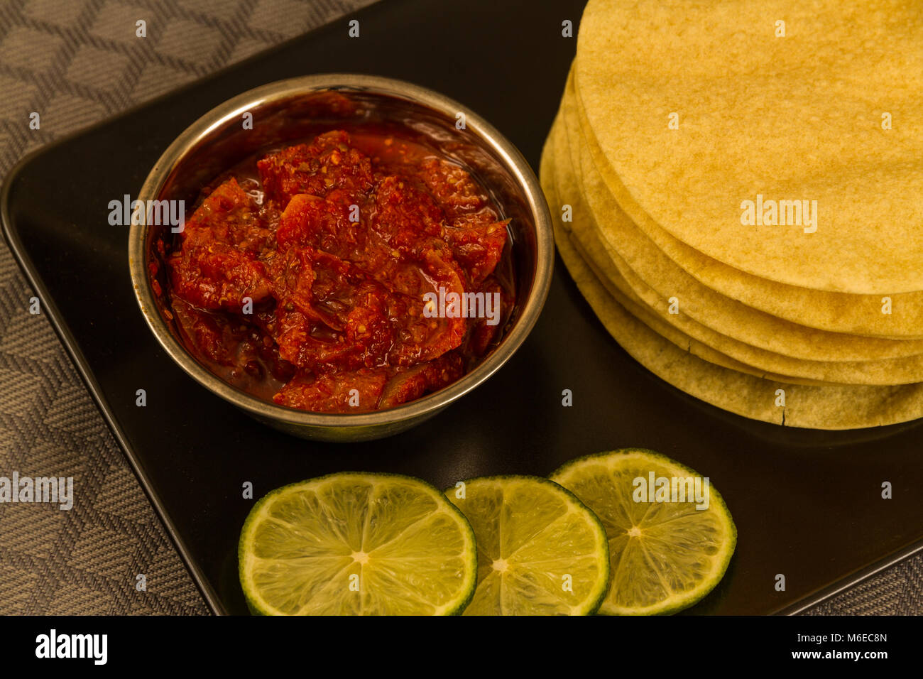 Indian poppadums stacked with bowl of lime pickle and sliced lime Stock ...