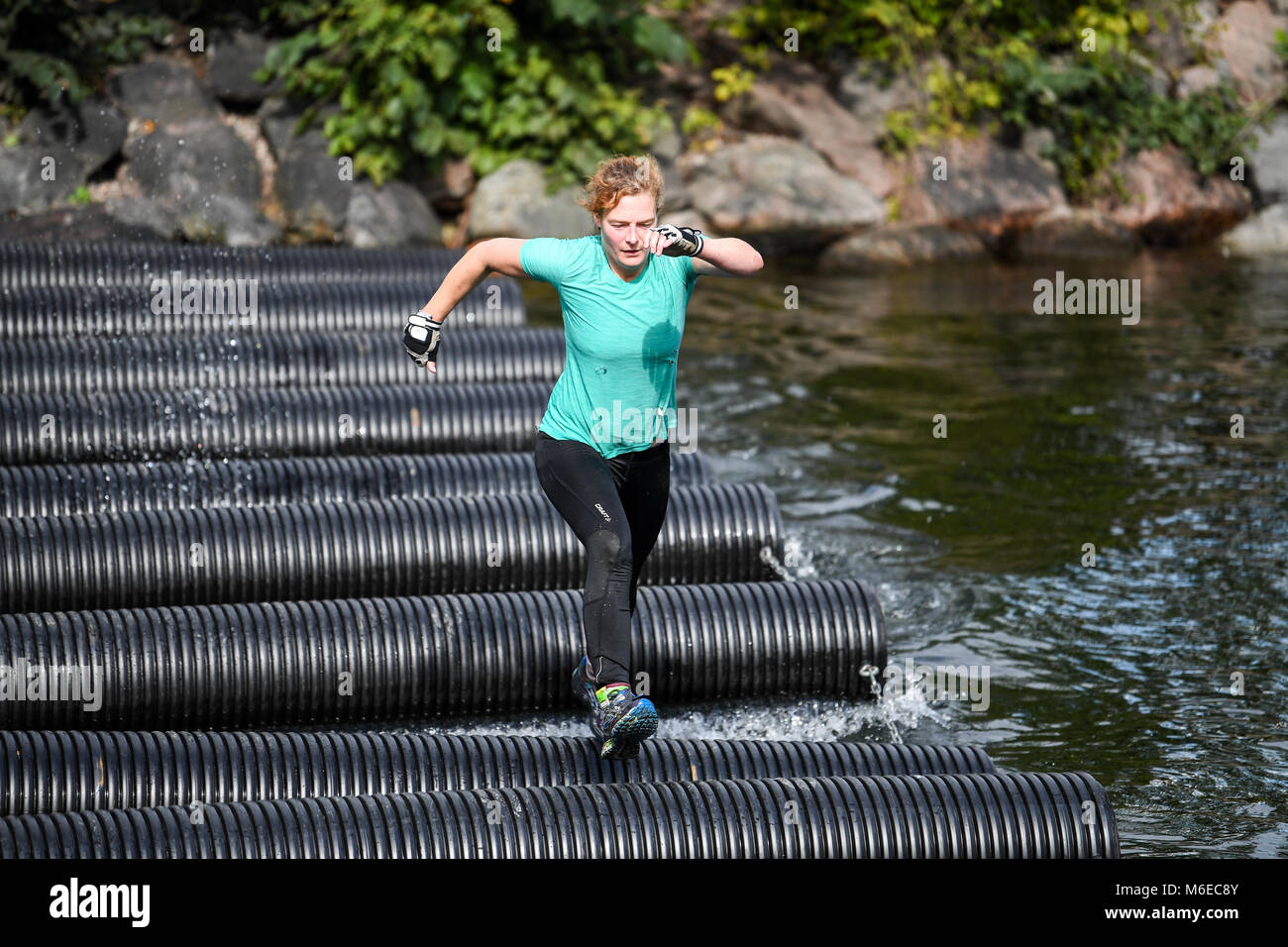Participant crossing a water obstacle during Action run 2017 obstacle ...