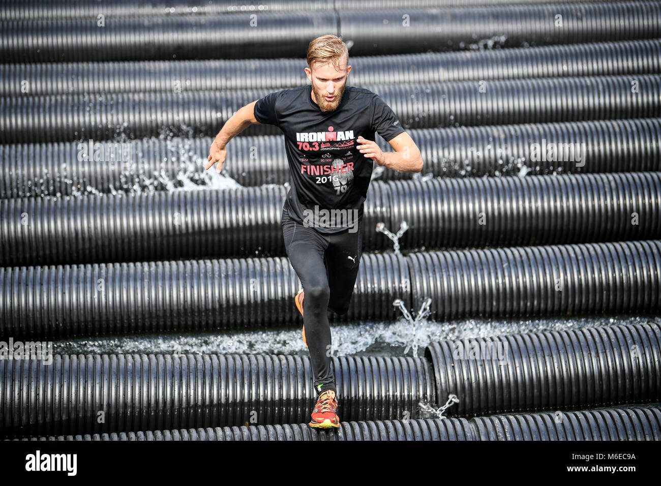 Participant crossing a water obstacle during Action run 2017 obstacle ...