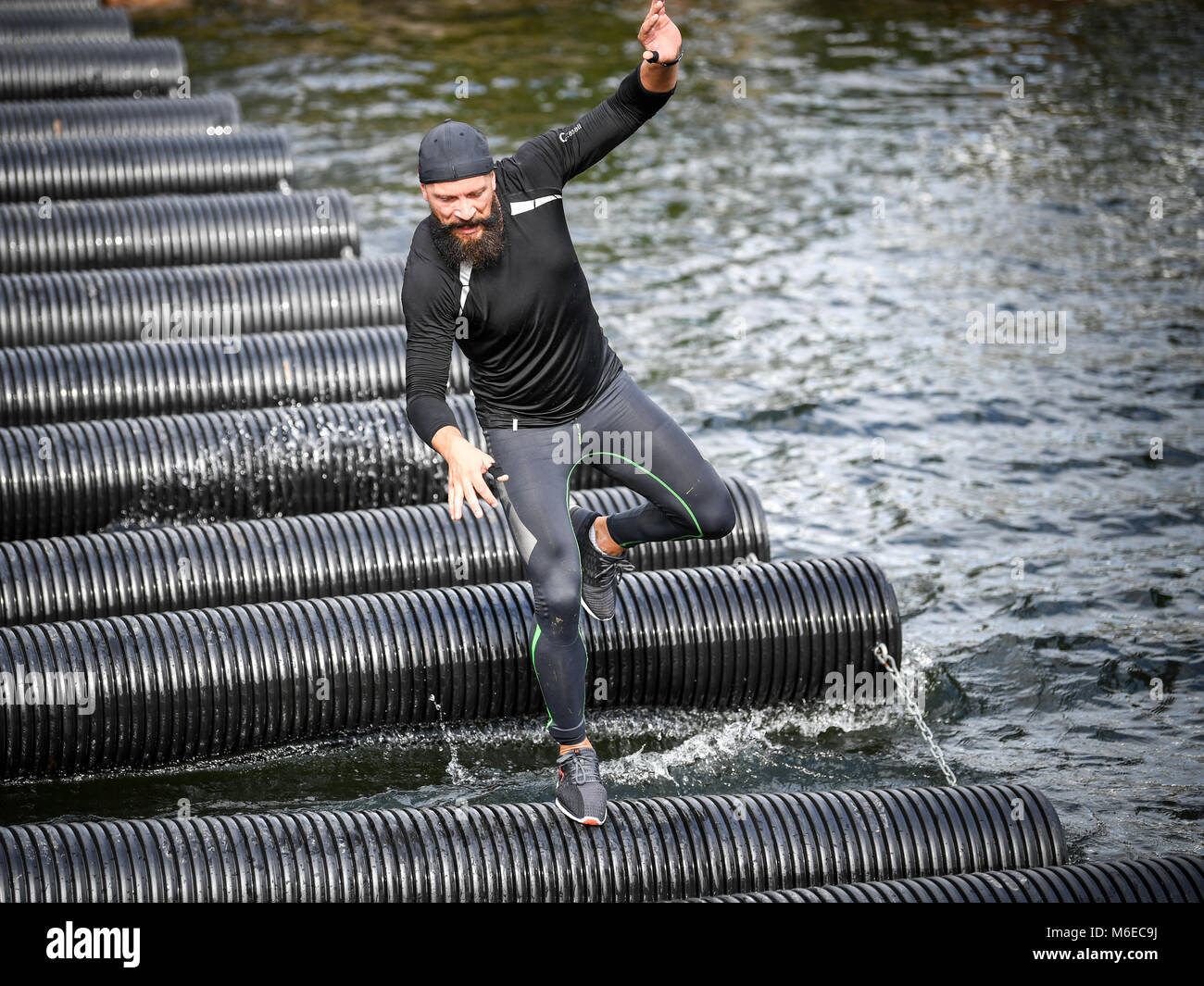 Participant crossing a water obstacle during Action run 2017 obstacle ...
