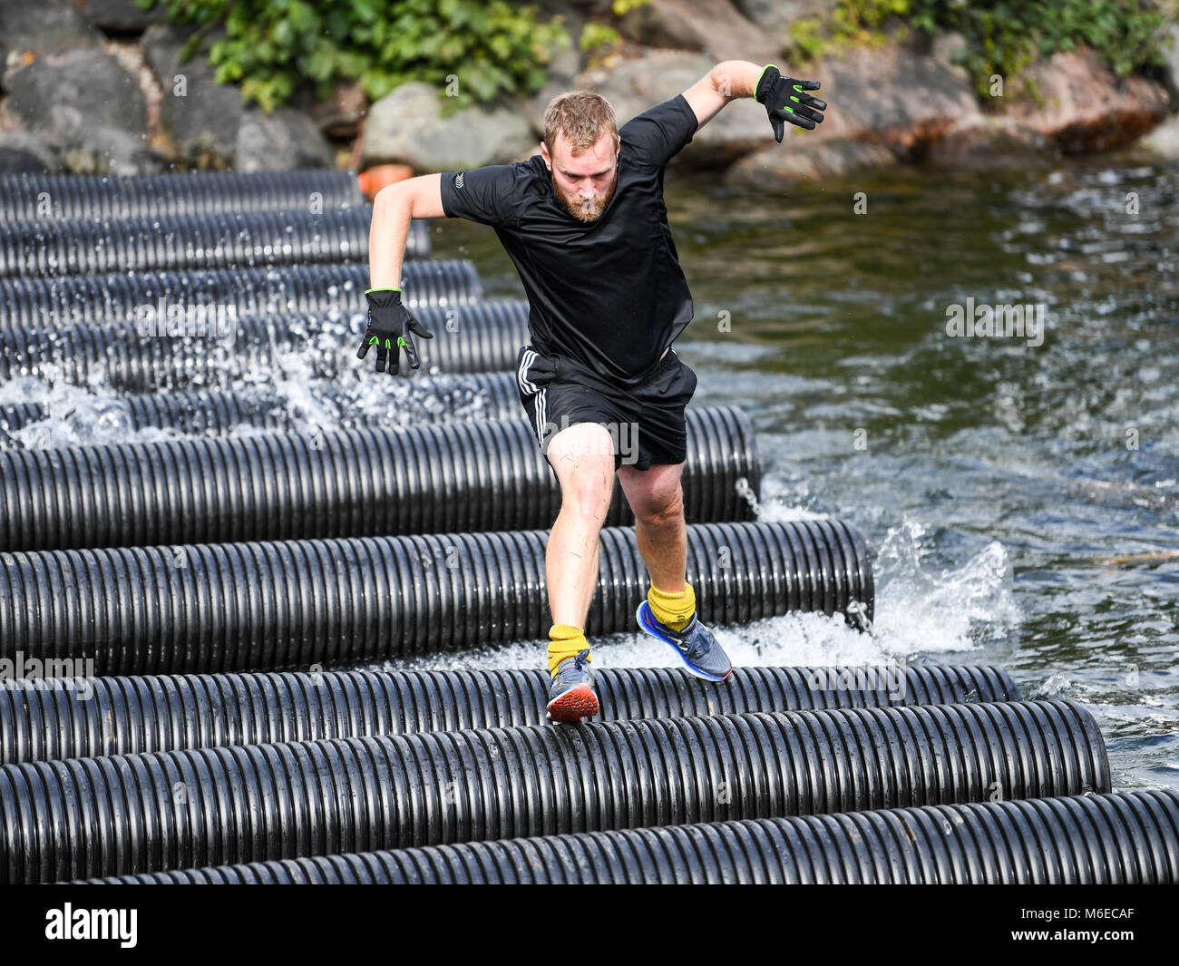 Participant crossing a water obstacle during Action run 2017 obstacle ...