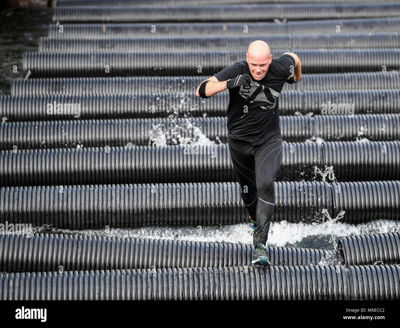 Participant crossing a water obstacle during Action run 2017 obstacle ...