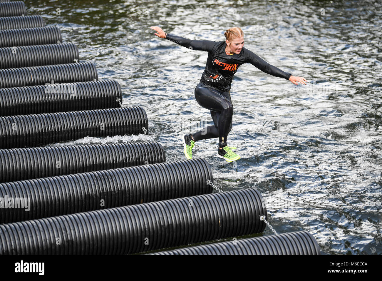Participant crossing a water obstacle during Action run 2017 obstacle ...
