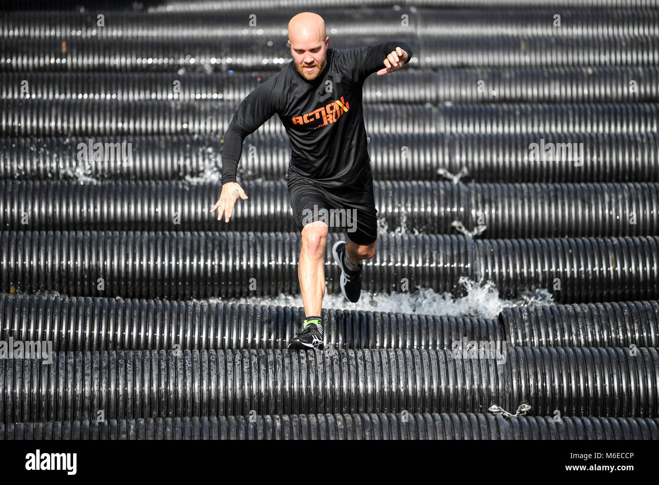 Participant crossing a water obstacle during Action run 2017 obstacle ...