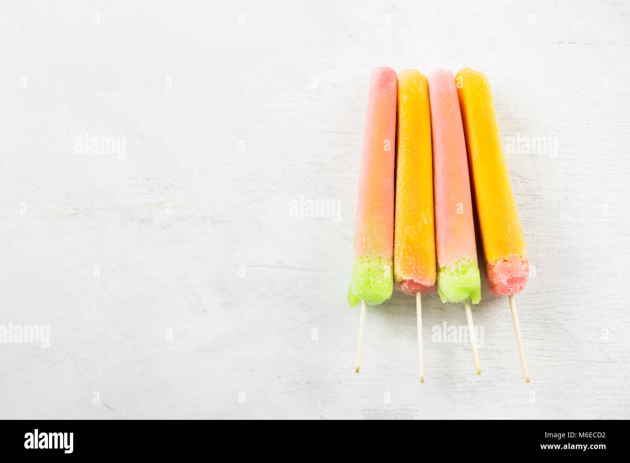 Multi-colored popsicles on a white background. Top view, copy space ...