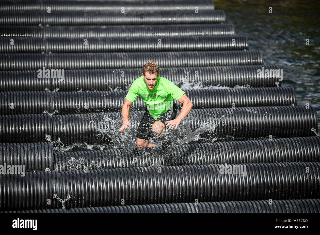 Participant crossing a water obstacle during Action run 2017 obstacle ...