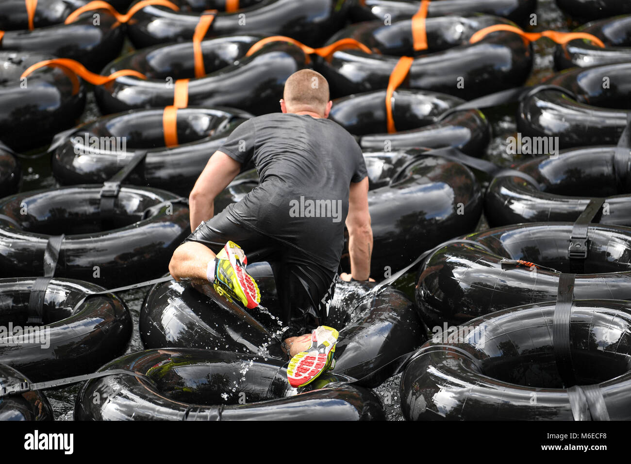 Participant crossing a water obstacle during Action run 2017 obstacle ...