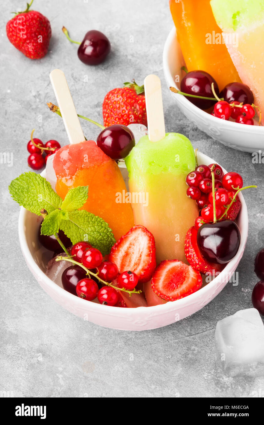 Multi-colored popsicles with strawberry, red currant and cherry on a ...