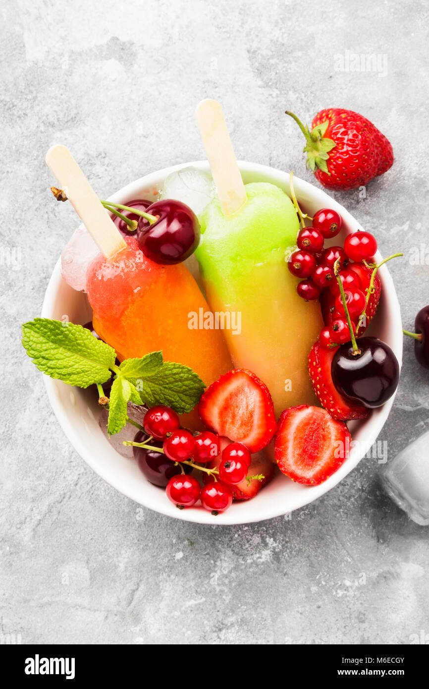 Multi-colored popsicles with strawberry, red currant and cherry on a ...