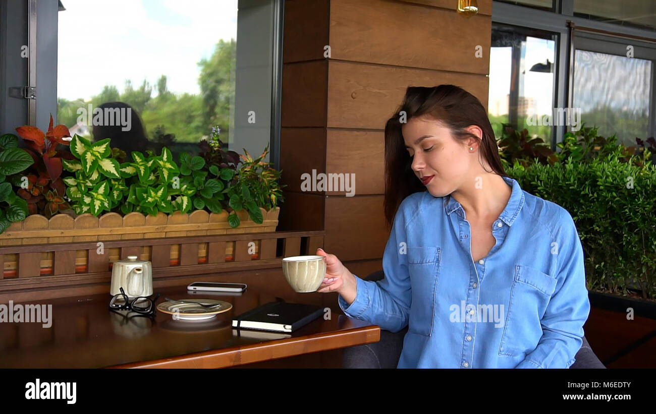 Charming girl drinking tea at restaurant Stock Photo - Alamy