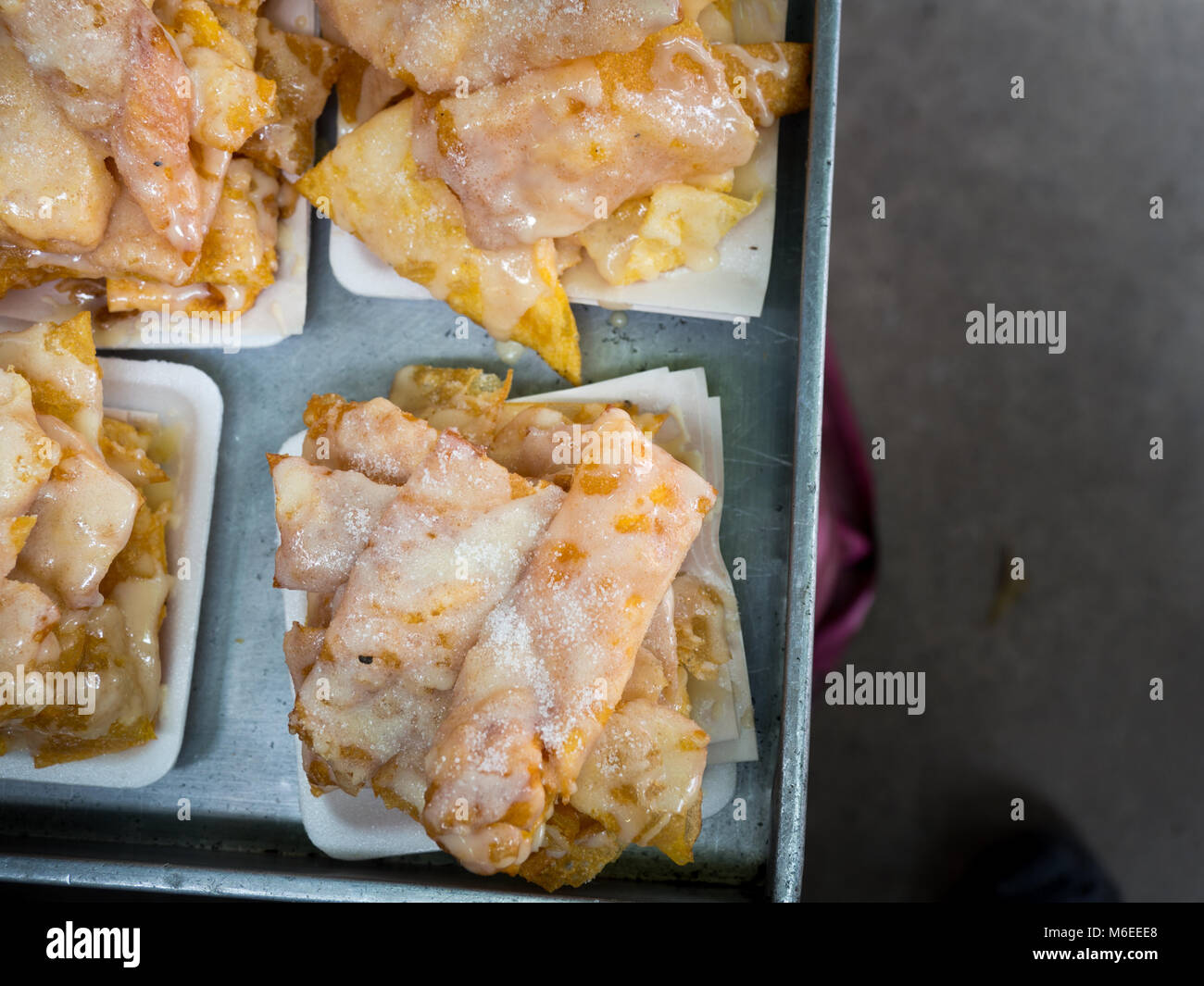Crispy fried roti with sweetened condensed milk and sugar on paper tray ...
