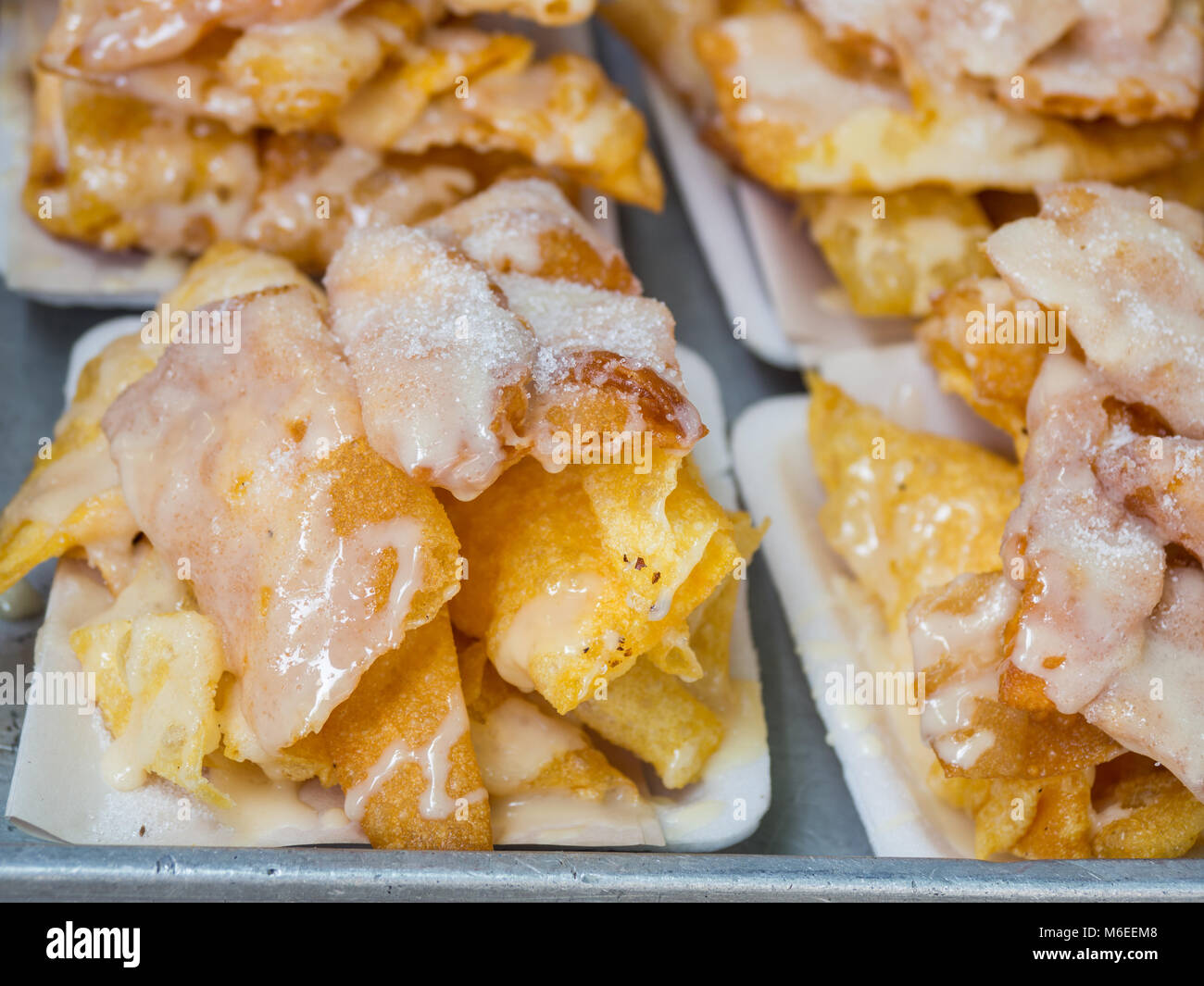 Crispy fried roti with sweetened condensed milk and sugar on paper tray ...