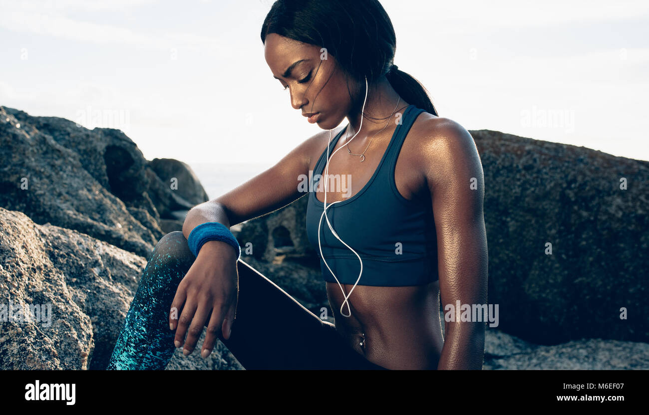 Tired woman with standing outdoors and relaxing after workout. African ...