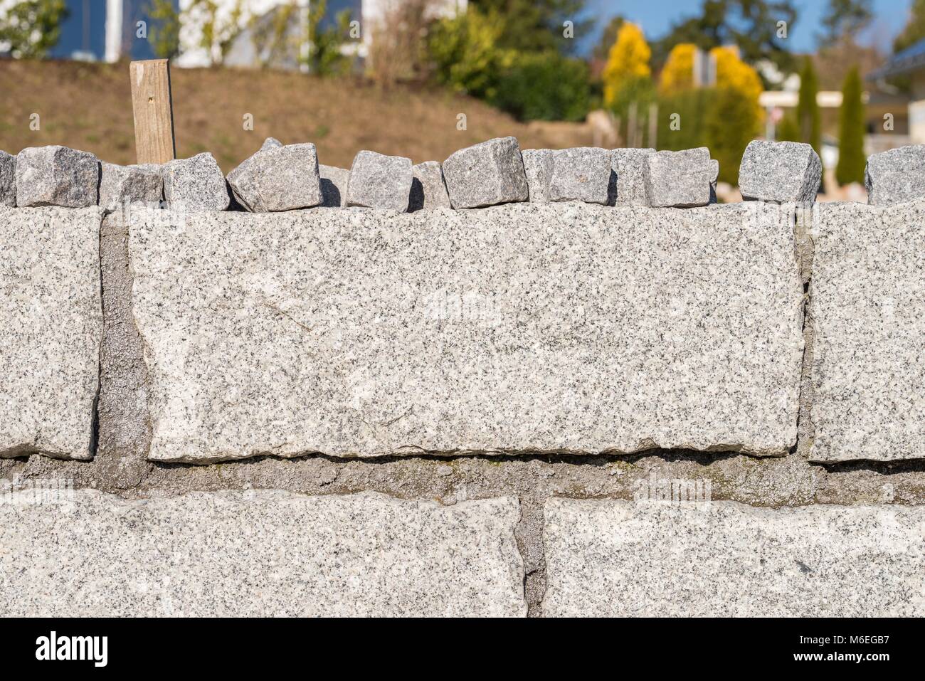 Granite Wall and many small granite stones for road coating Stock Photo ...