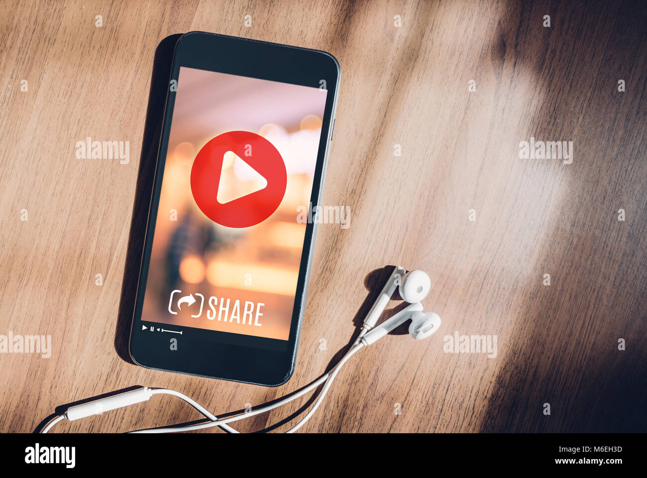 mobile with viral video advertising on phone screen at blur wood table ...