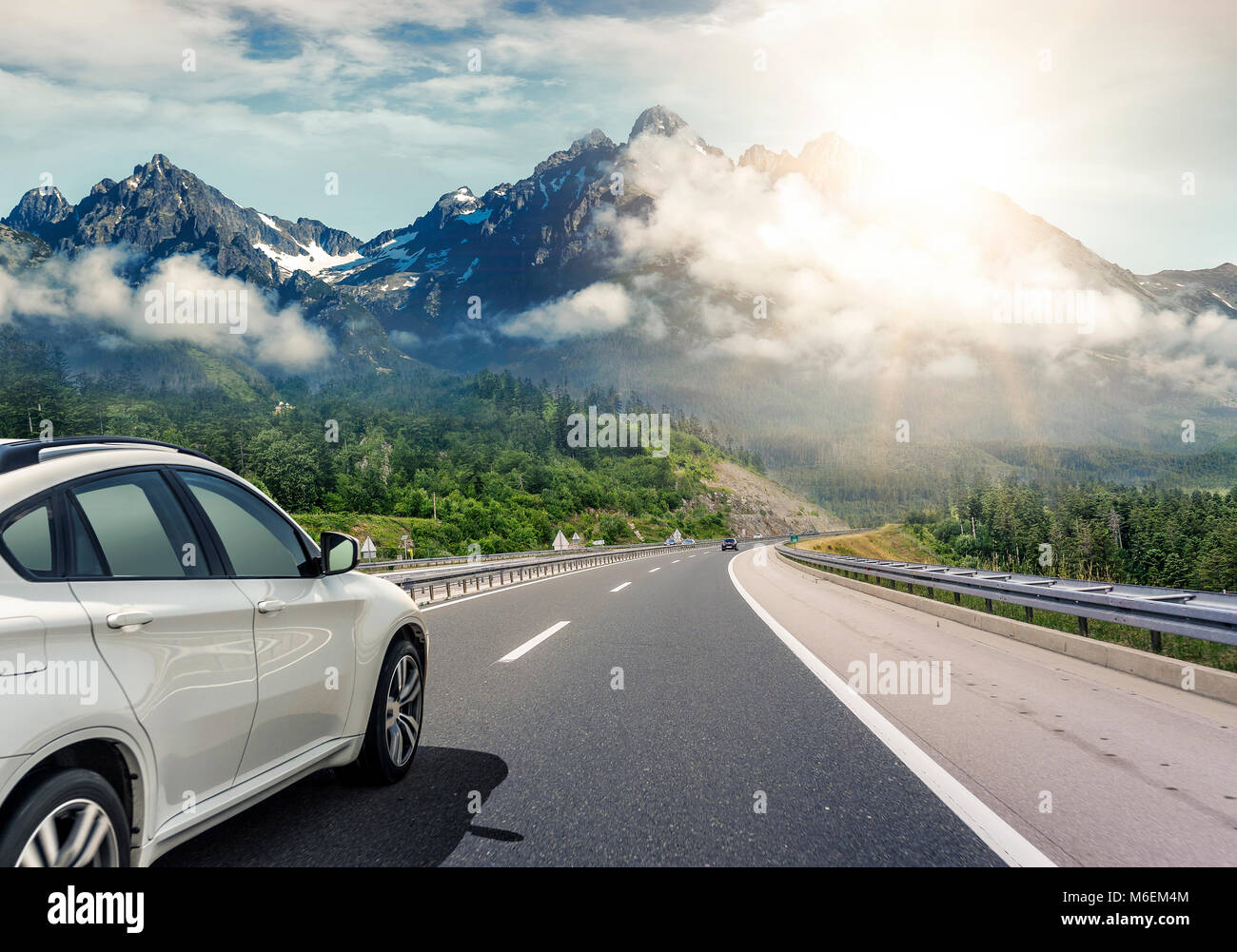 A white car rushing along a high-speed highway in the sun Stock Photo ...