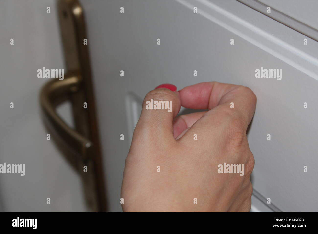 Female Hand knocking on door Stock Photo - Alamy