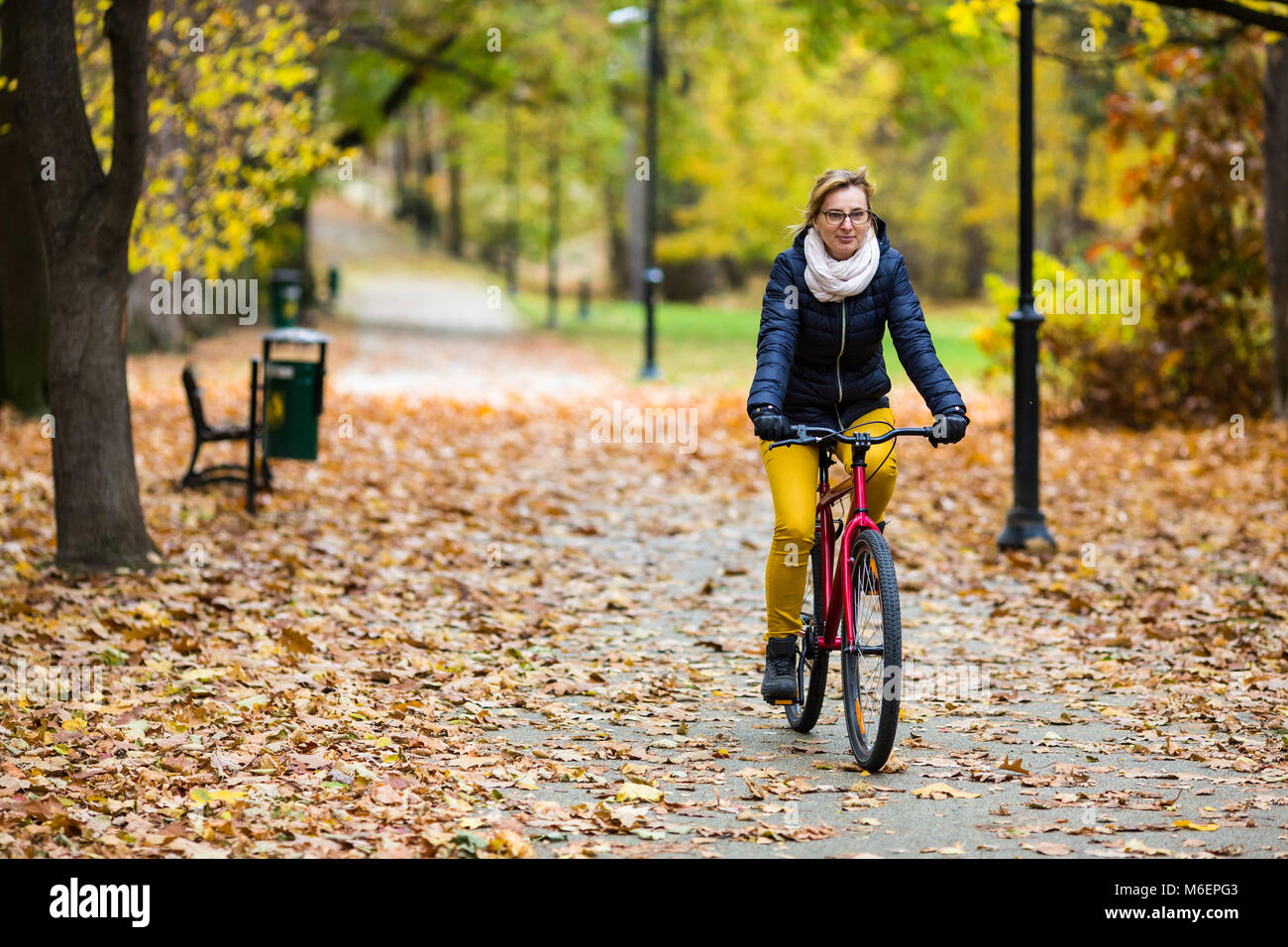 Urban biking - woman riding bike in city park Stock Photo - Alamy