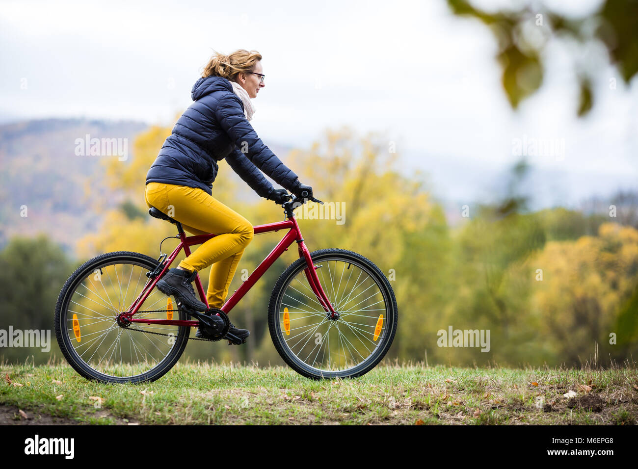 Urban biking - woman riding bike in city park Stock Photo - Alamy