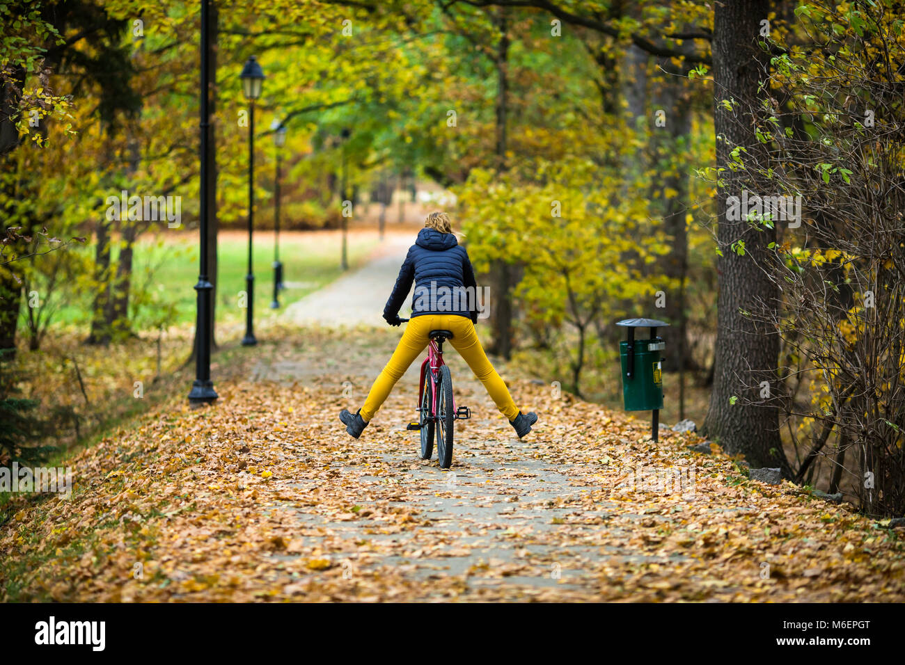 Urban biking - woman riding bike in city park Stock Photo - Alamy