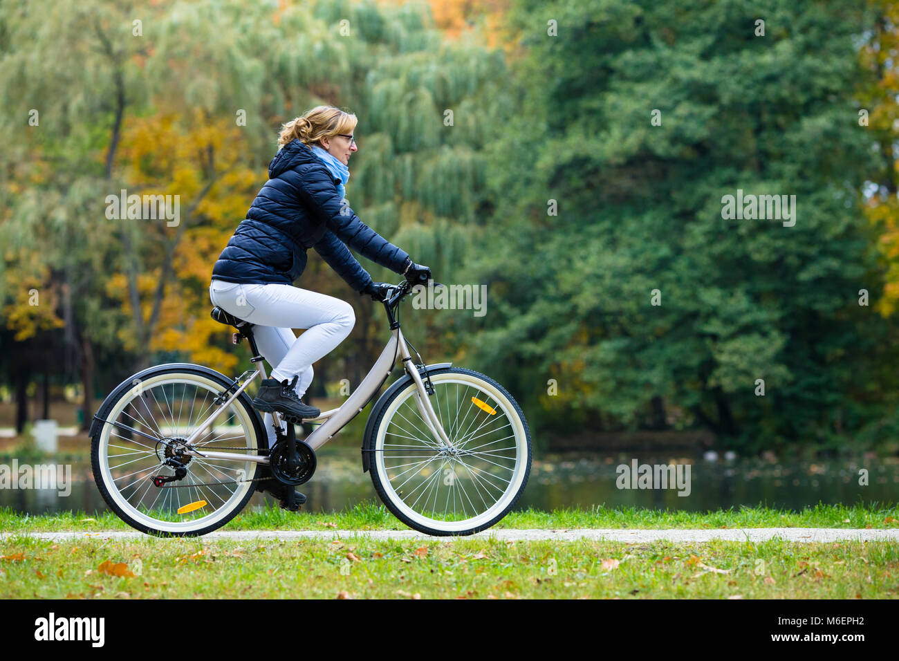 Urban biking - woman riding bike in city park Stock Photo - Alamy