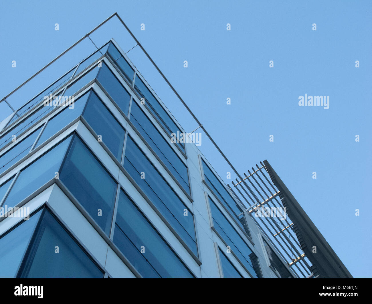 Corporate building. Low angle view of a diagonal glass facade, light ...