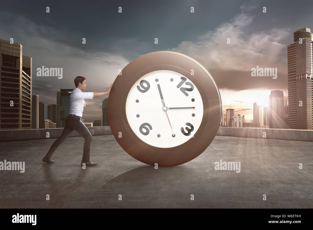 Handsome asian businessman pushing a clock on the rooftop Stock Photo ...